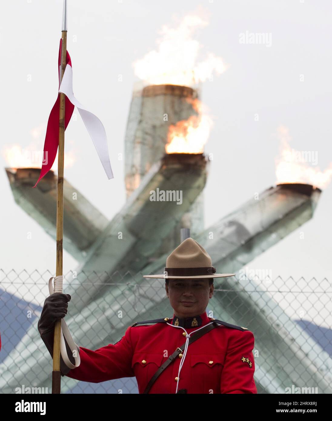 Members of the RCMP Musical Ride pose in front of the Olympic cauldron ...