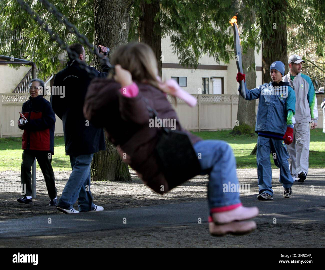 A young girl riding on a swing watches as Will George carries the ...