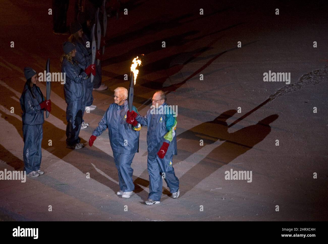 Betty and Rolly Fox carry the Paralympic flame into the stadium during ...