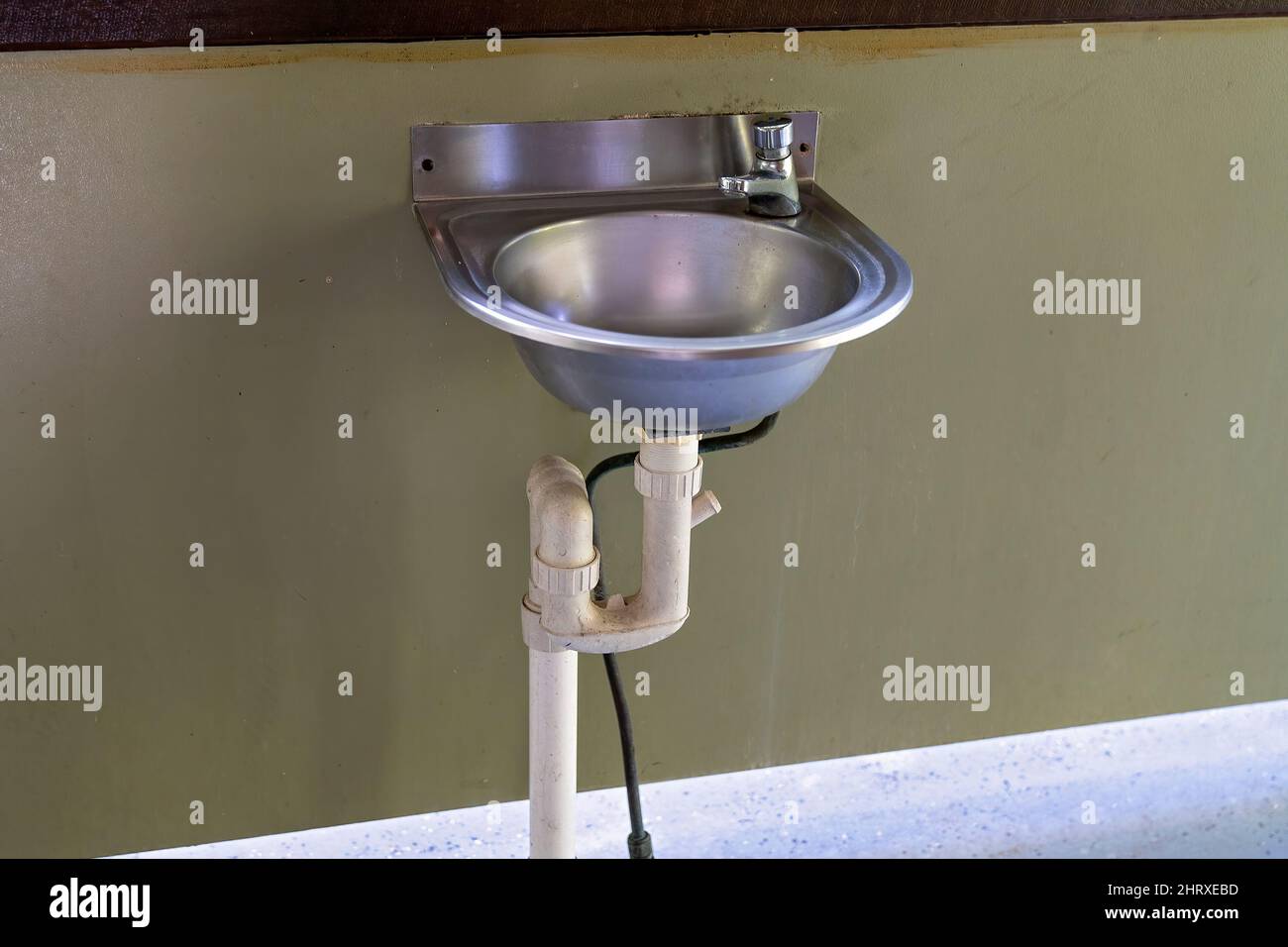 Small open basin and tap attached to a public toilet block Stock Photo ...