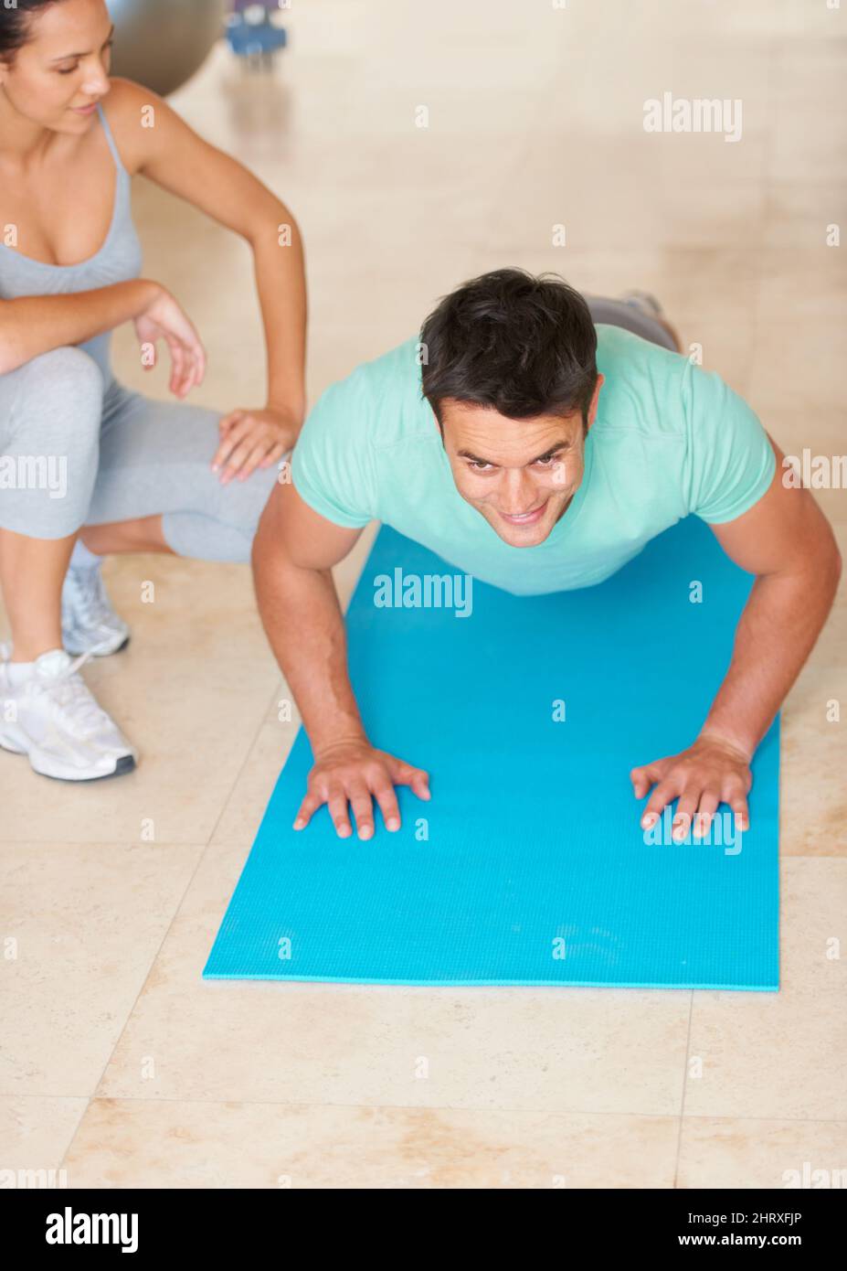 And another one.... A fitness instructor showing a young man how to do ...