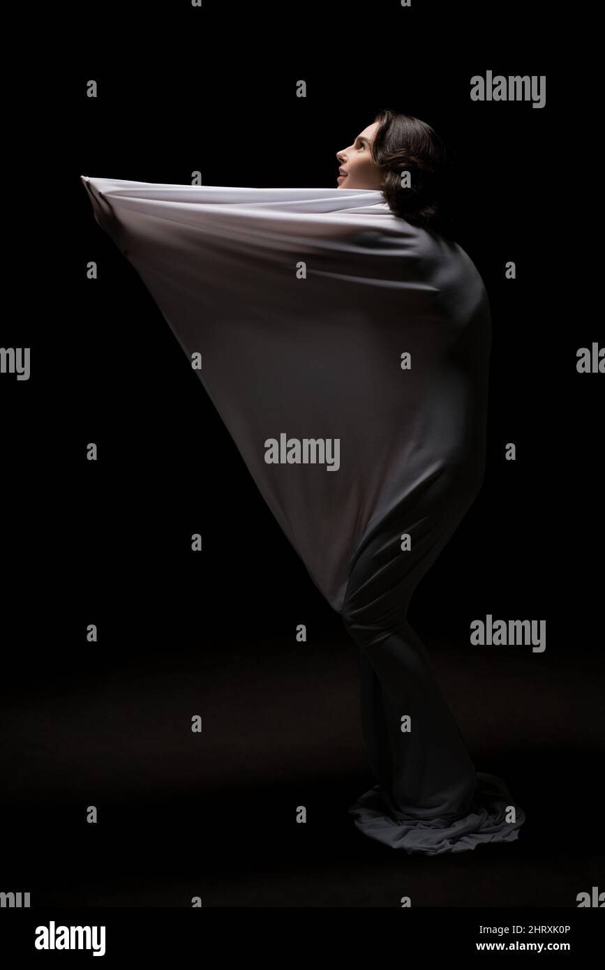 Woman wrapped in cloth outstretching arms in studio Stock Photo - Alamy