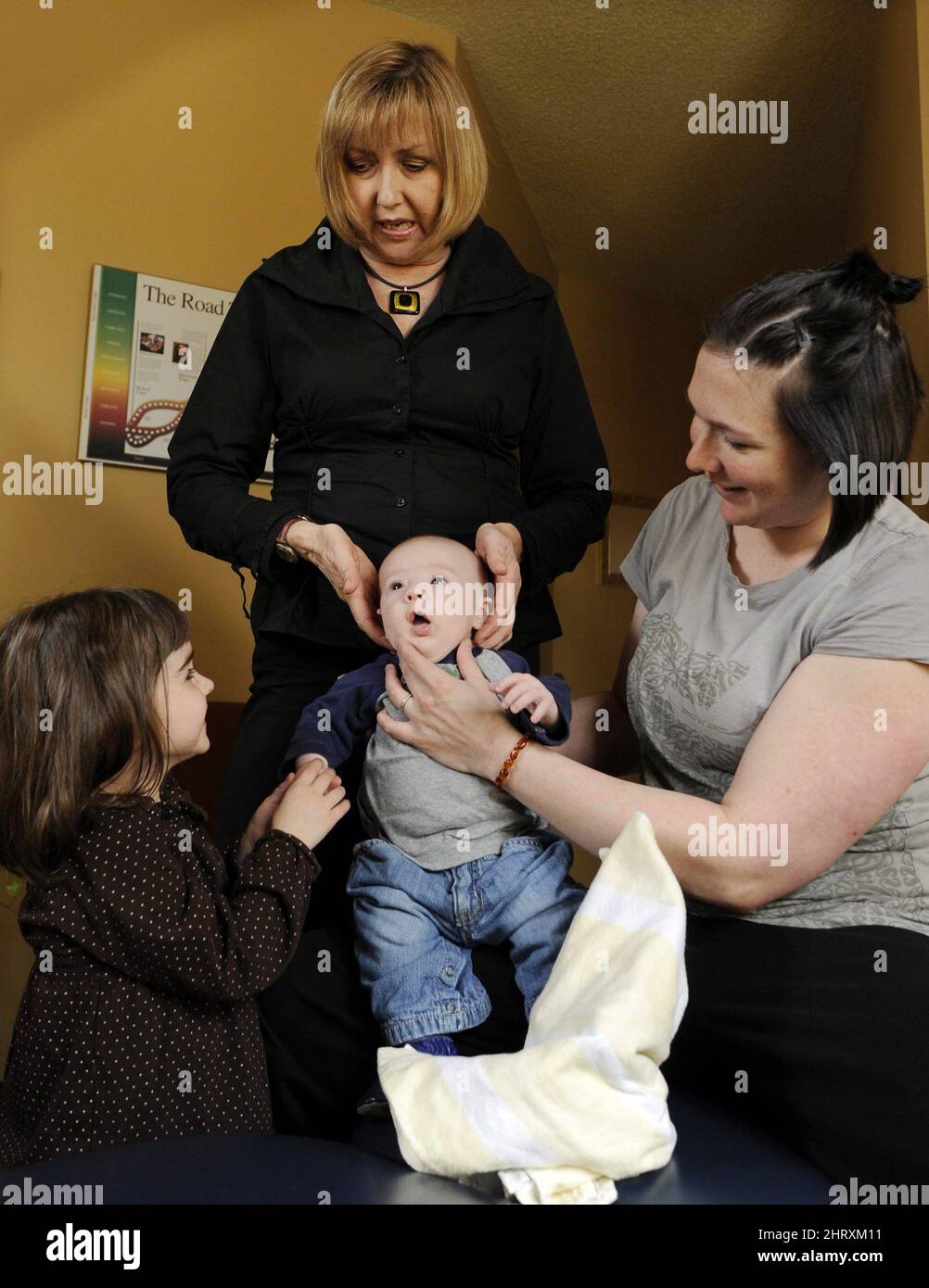 Chiropractor Dr. Judy Forrester, top, works on two month old Brady with ...