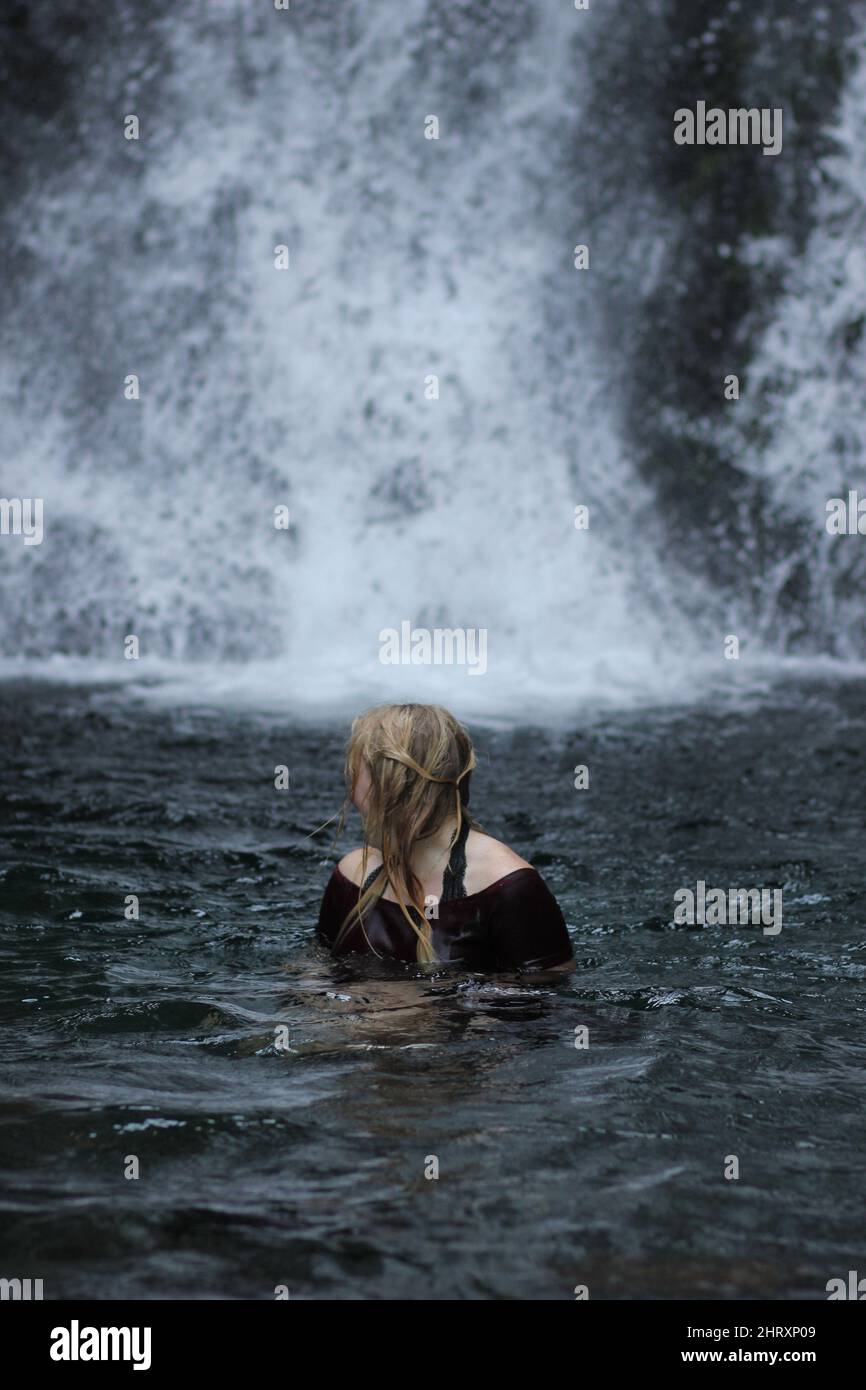 Woman in the water of waterfall Stock Photo - Alamy
