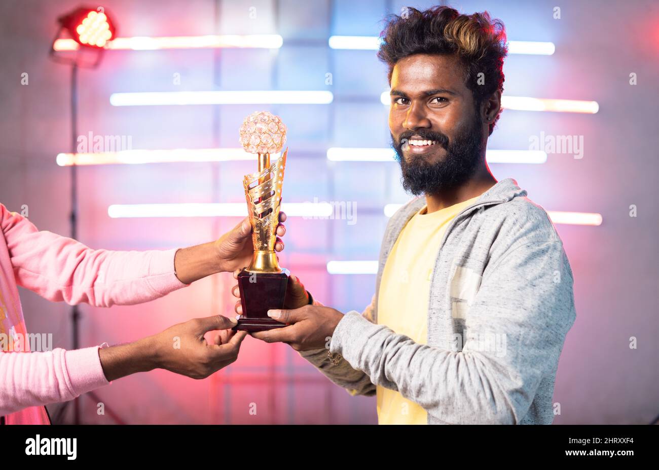 Excited dancer receving winner trophy in dancing compitation on stage ...