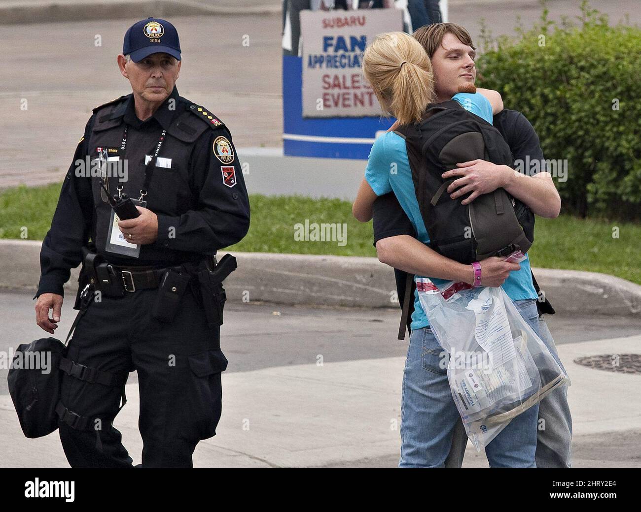 A police officer looks on as a man and woman hug following his release ...