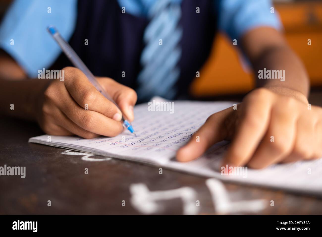 close up shot of girl kid on classroom writing notes on book at school ...