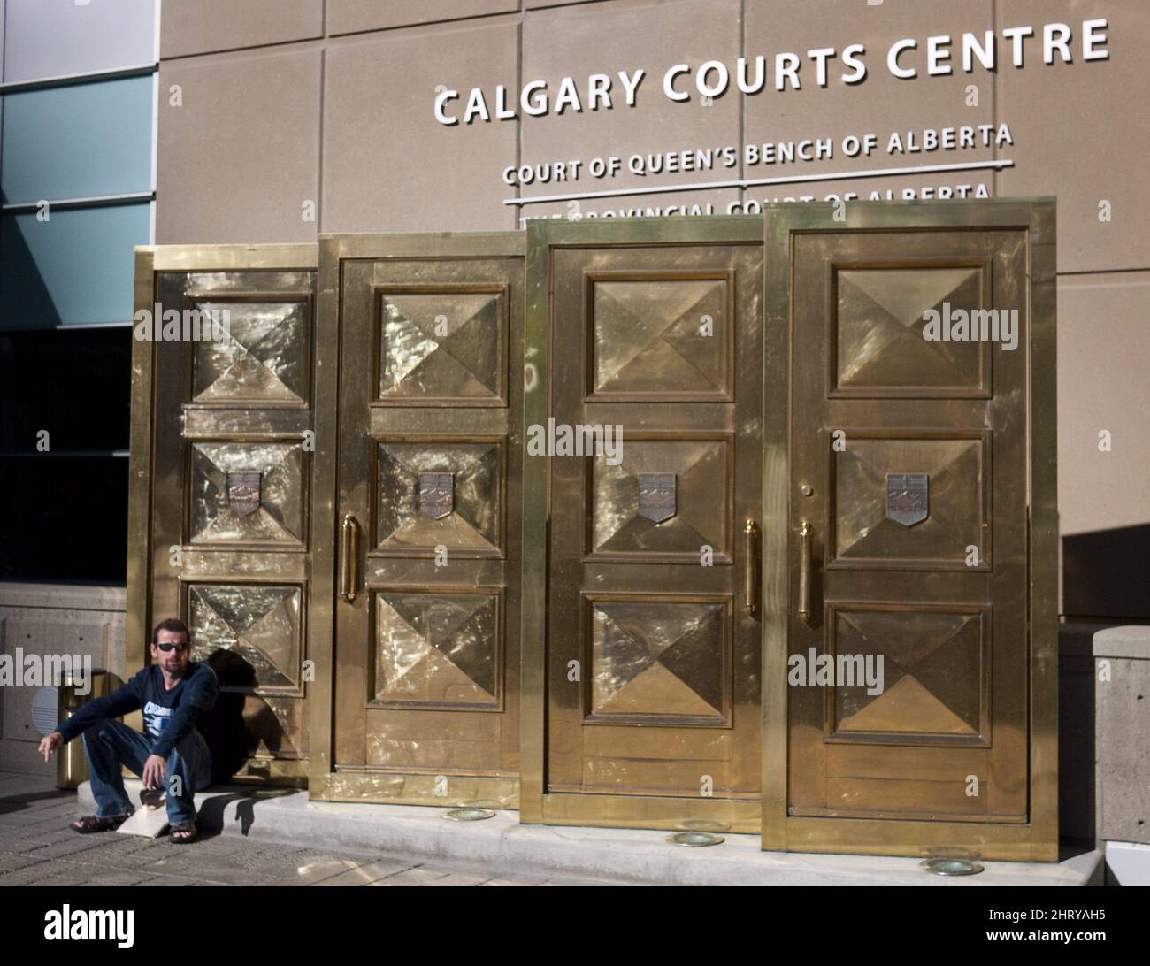 An unidentified man sits on the doorsteps of the Calgary Courts Centre ...
