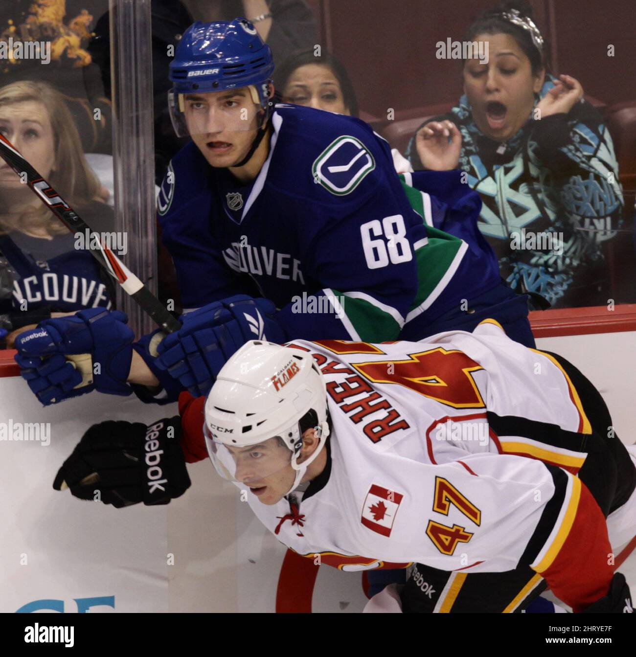 A fan reacts as Vancouver Canucks' Chris Tanev, top, and Calgary Flames ...