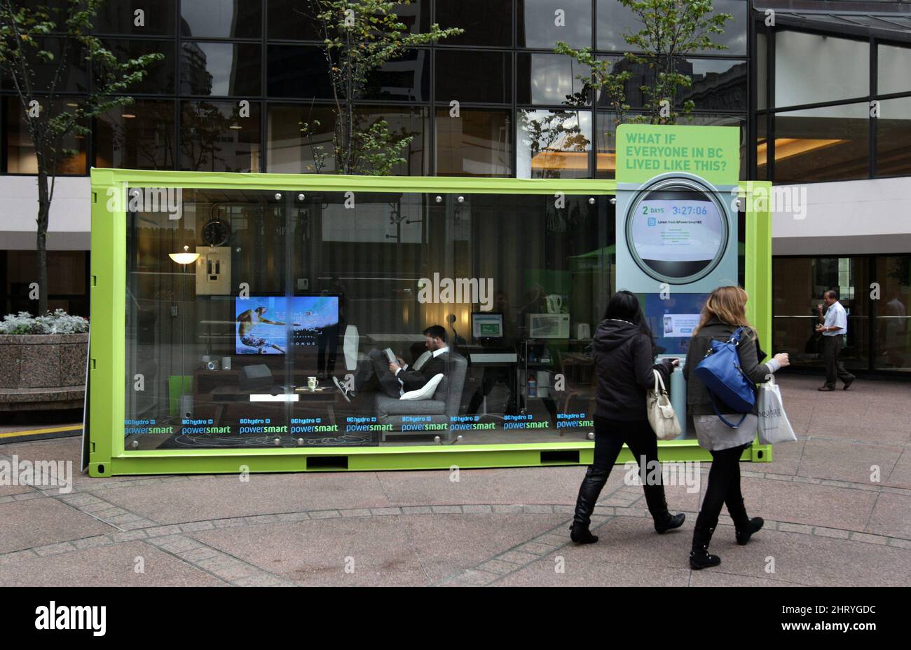 Pedestrians pass by as actor Jason Cox sits in a temporary three by six ...
