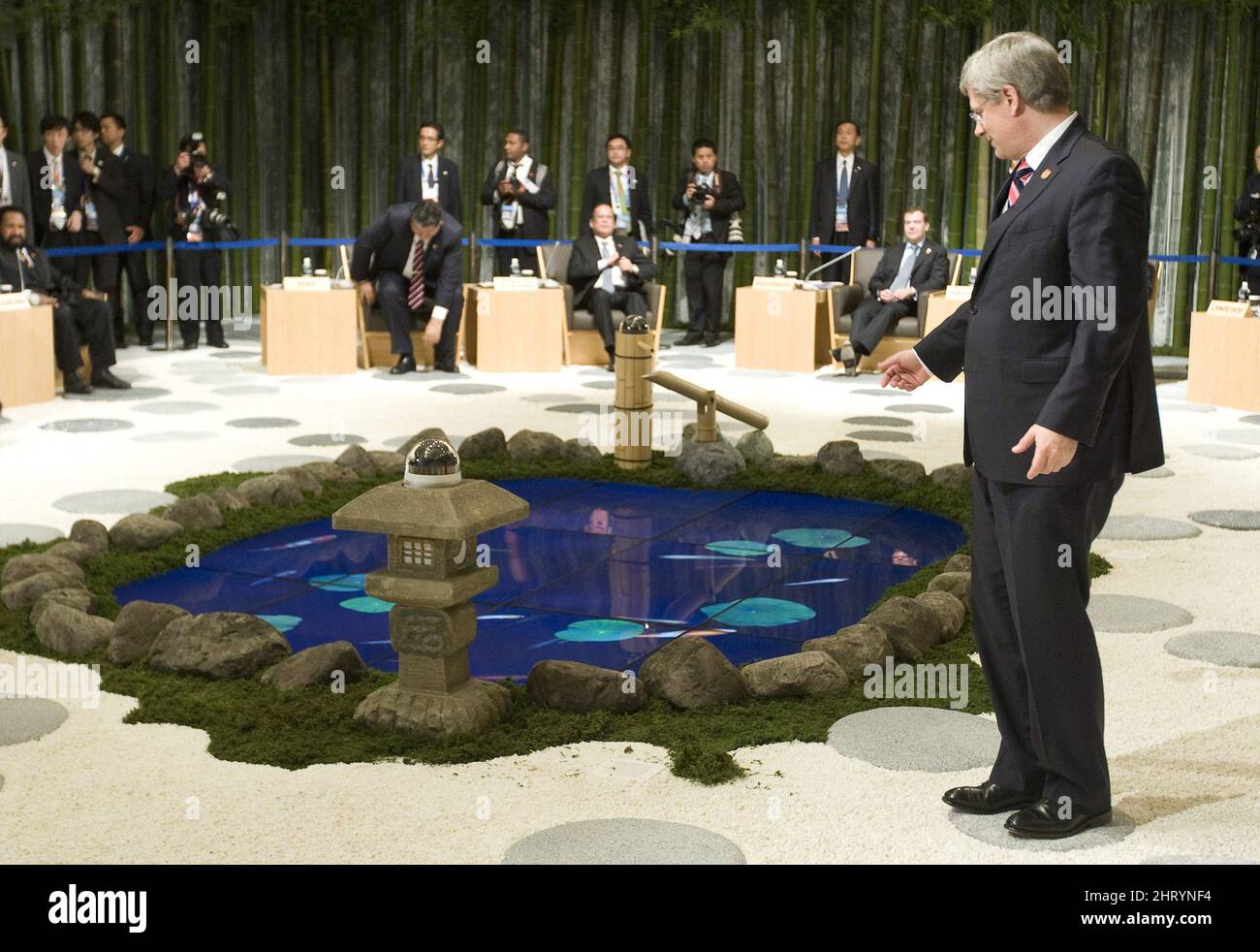 Prime Minister Stephen Harper stands next to a fake lake in the middle ...