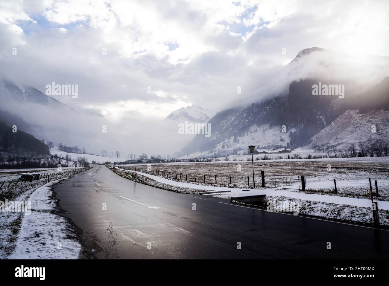 Long road leads to the snowy mountains Stock Photo - Alamy