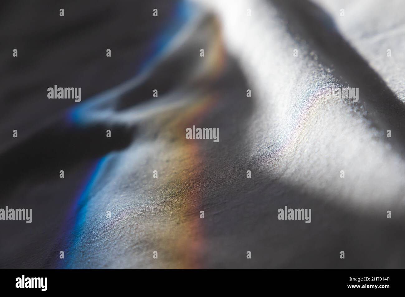 Beam of sunlight with spectrum colors goes over white fabric, physical ...