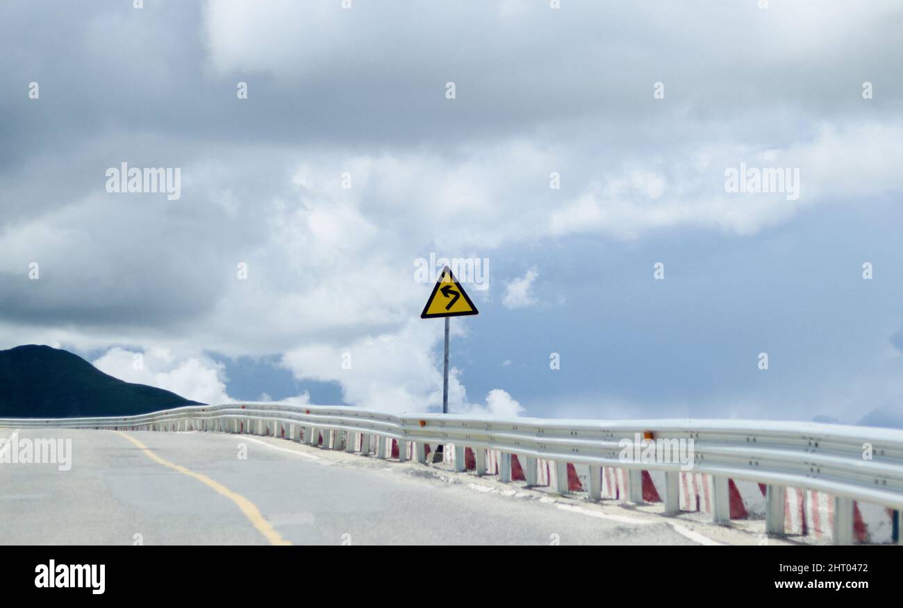 Road sign with an arrow on a cloudy sky background Stock Photo - Alamy