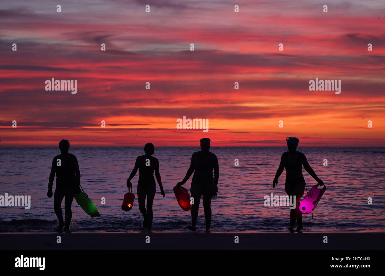 Sea swimmers emerge before dawn from the waters of the North Sea at ...
