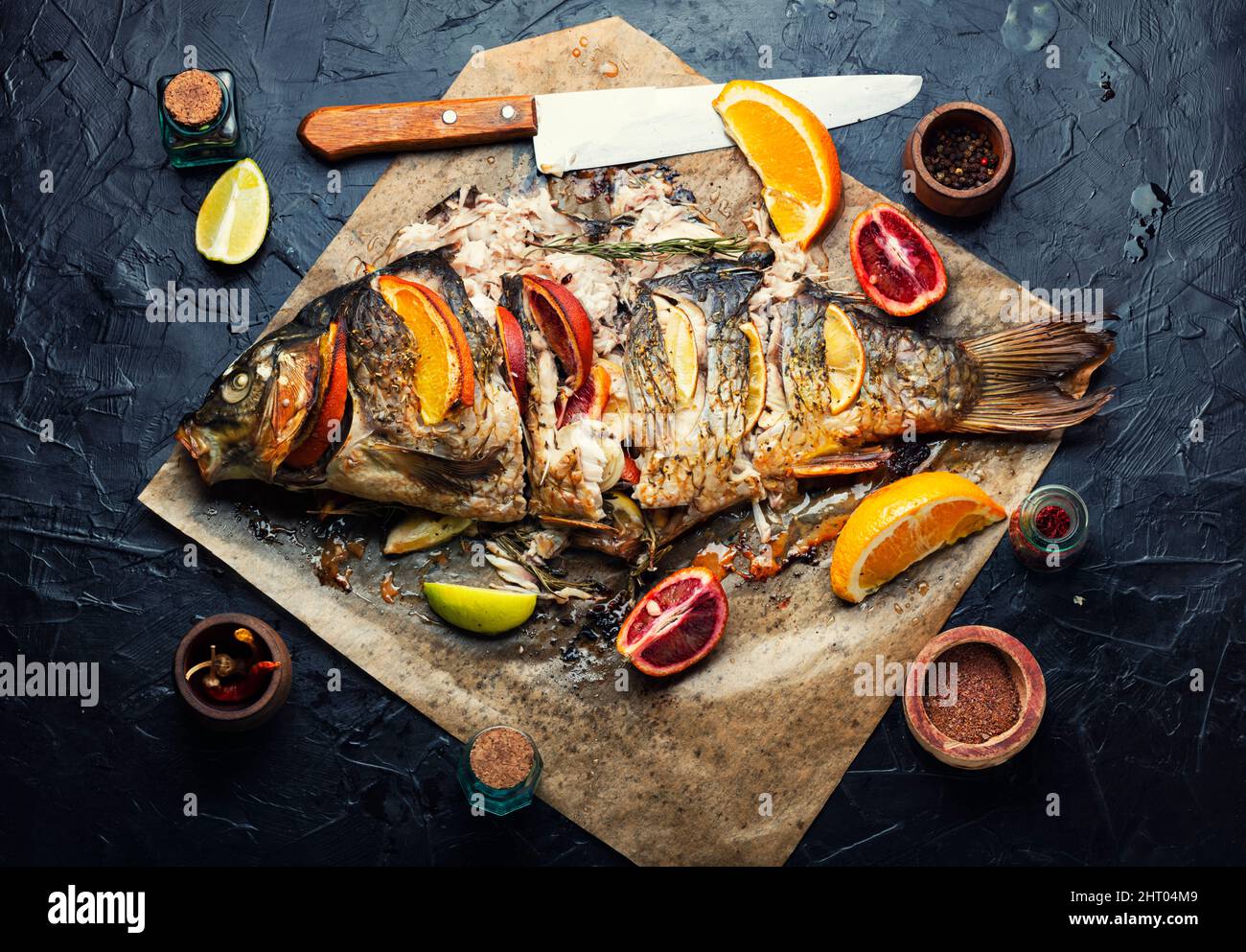 Sliced fried fish , baked fish with citrus fruits .Carp on baking paper ...