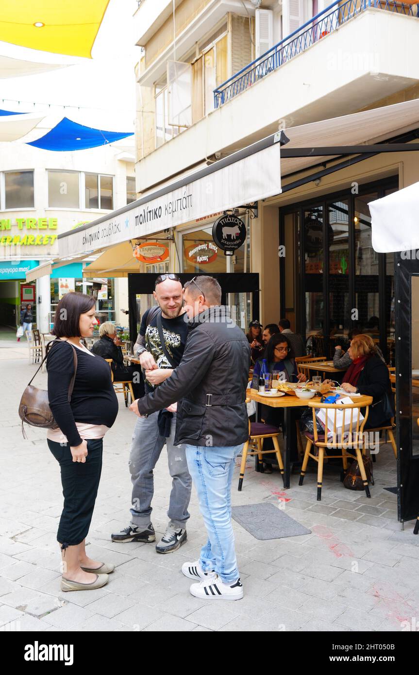 Group of people having a talk in front of a restaurant in the city ...
