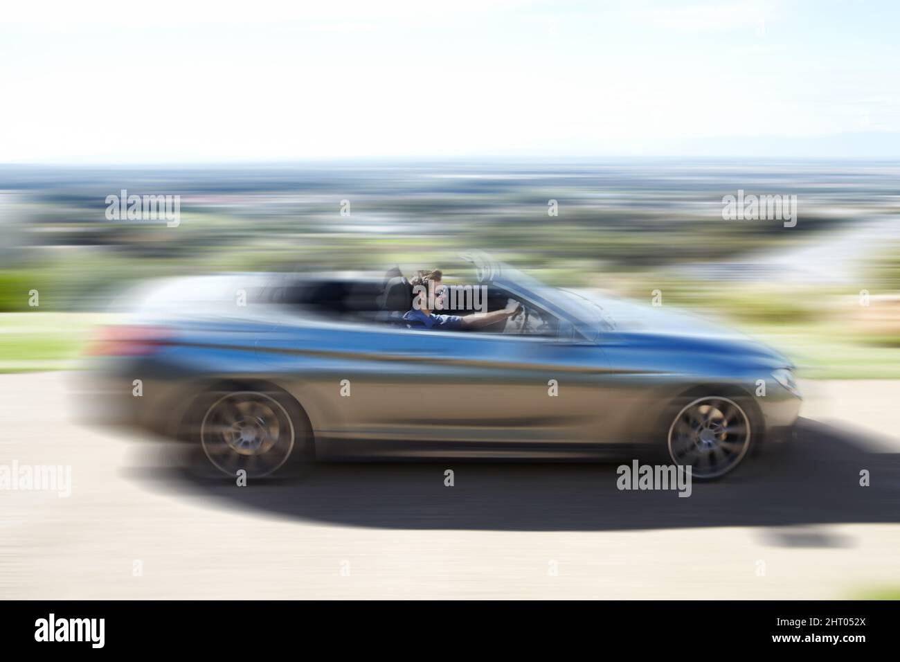 Hes a speed freak. A young man speeding on the open road in his silver ...