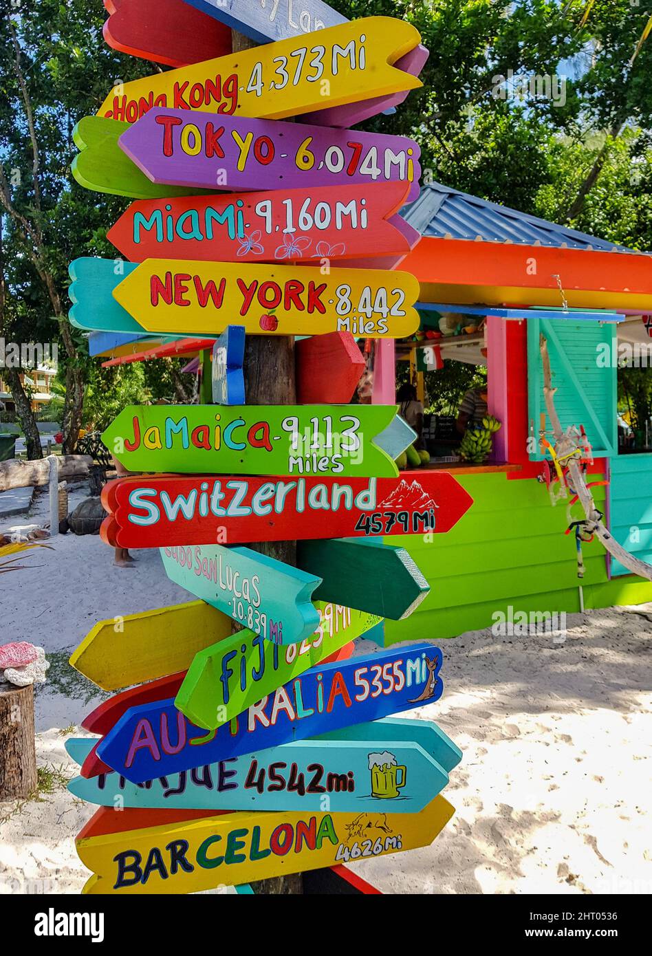 Colorful sign post in front of a tropical beach bar Stock Photo - Alamy