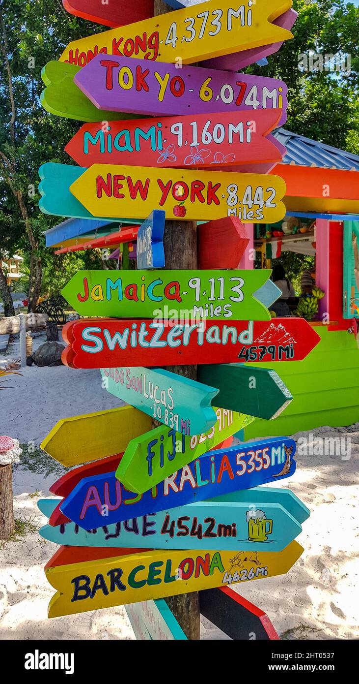Colorful sign post in front of a tropical beach bar Stock Photo - Alamy