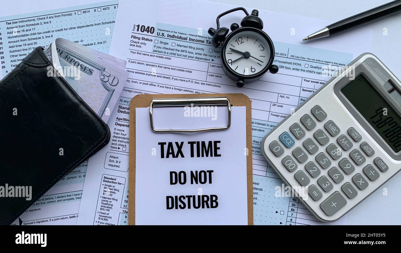 Top view of text on notepad - Tax time, do not disturb. With tax form ...