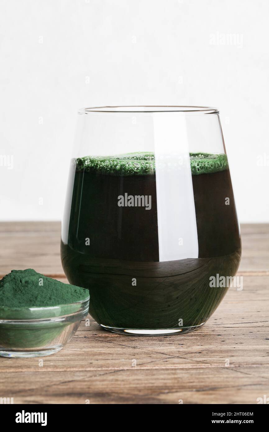 fresh green drink with spirulina in glass, spirulina powder with spoon ...