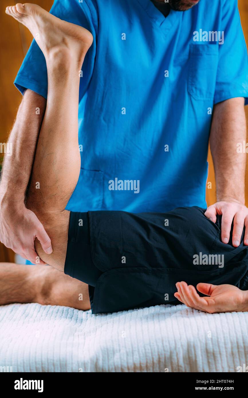 Physical therapist massaging injured leg of a male athlete Stock Photo ...