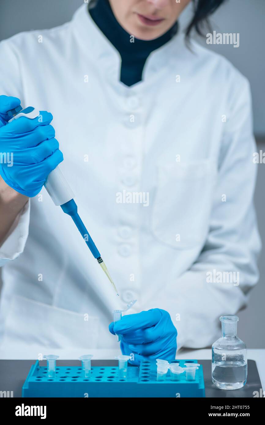 Laboratory technician pipetting liquid Stock Photo - Alamy