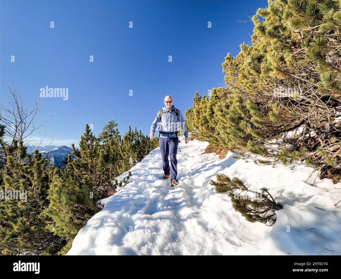Hiker walking on the snow-covered trails of the peak and smiling Stock ...