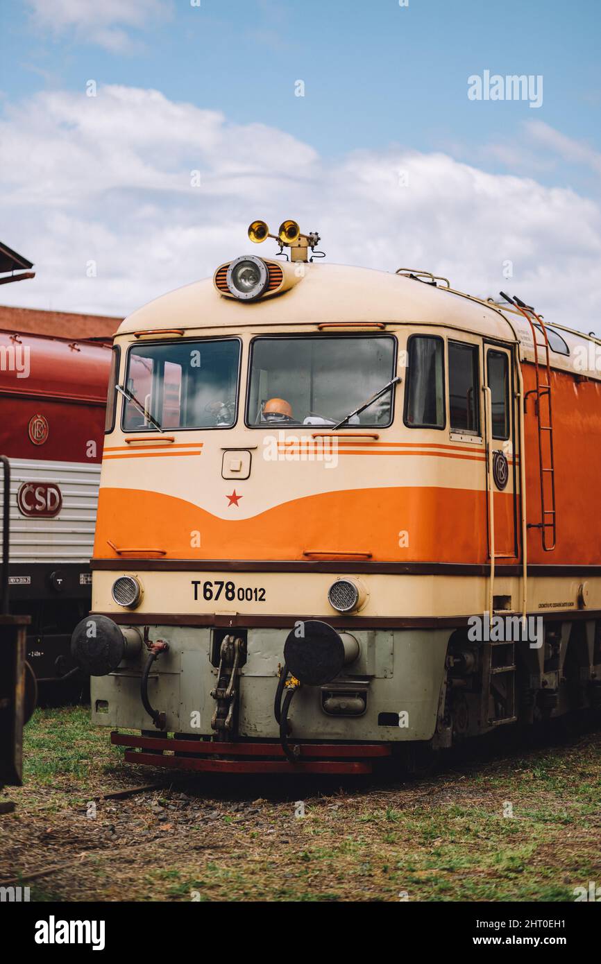 Vertical shot of orange diesel locomotive engine T678 under the blue ...