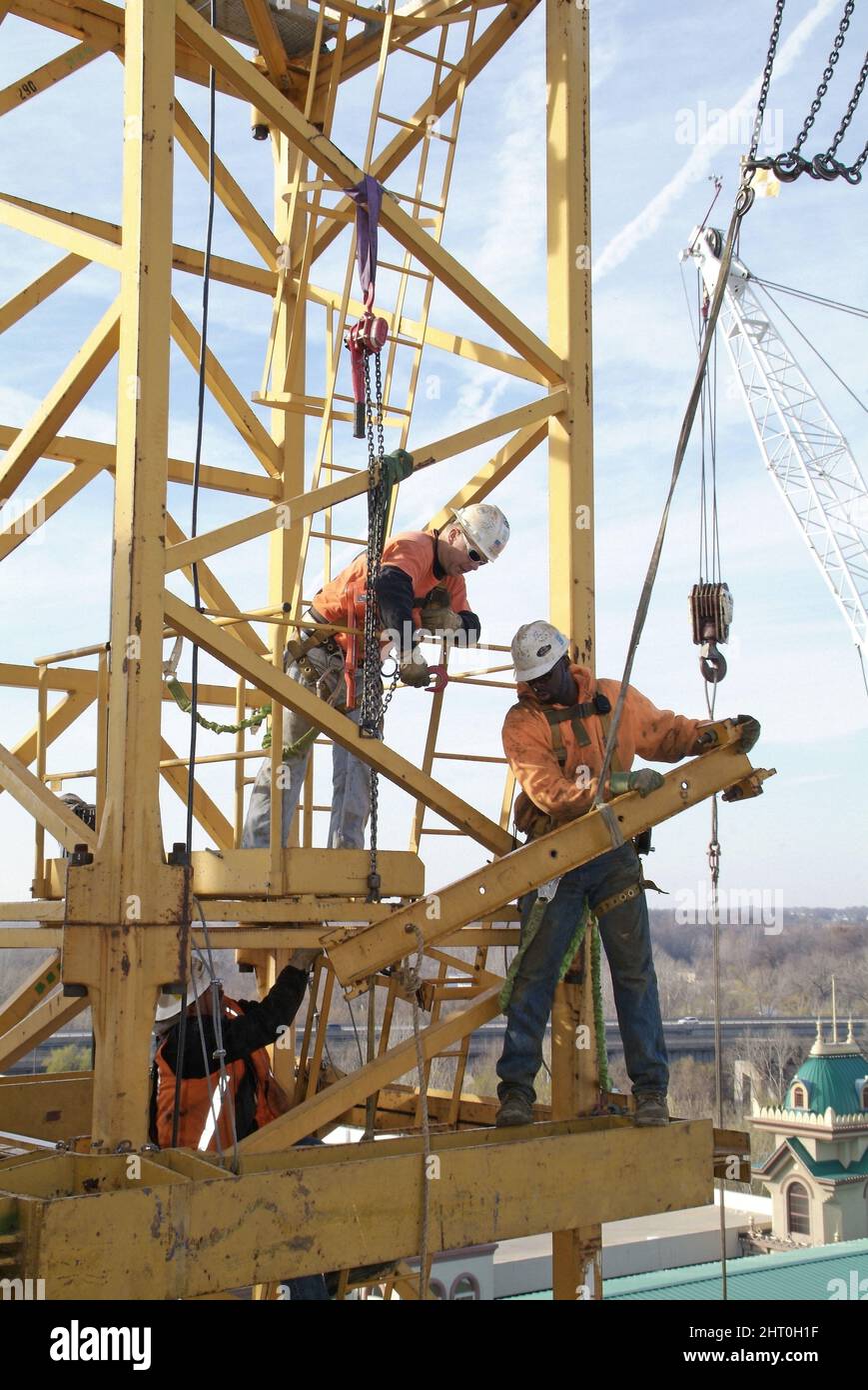 Vertical shot of people working near the construction cranes Stock ...