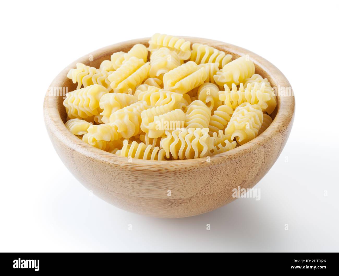 Uncooked radiatori pasta in wooden bowl isolated on white background ...