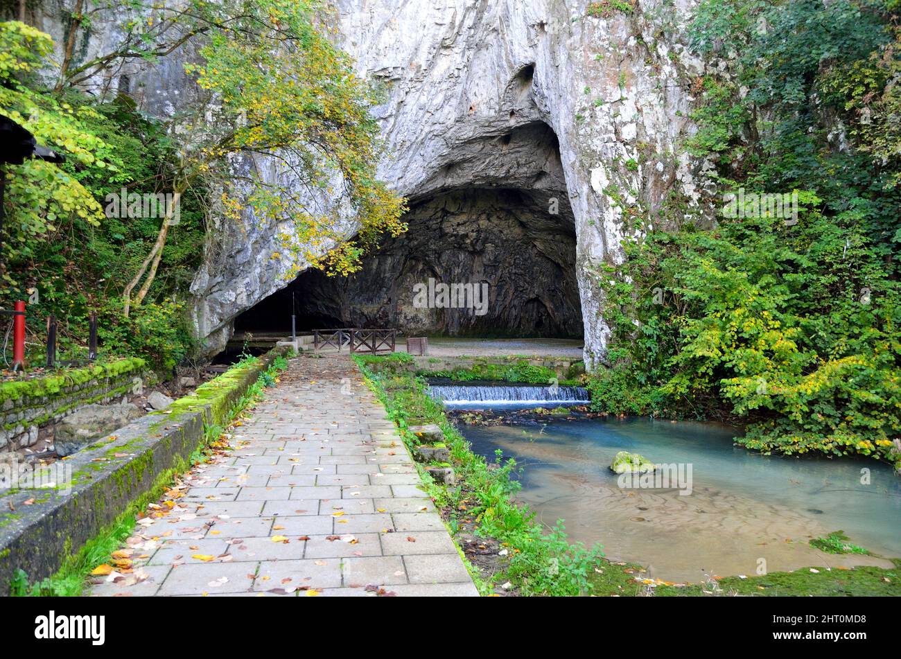 Narrow empty path leading to an old cave Stock Photo - Alamy