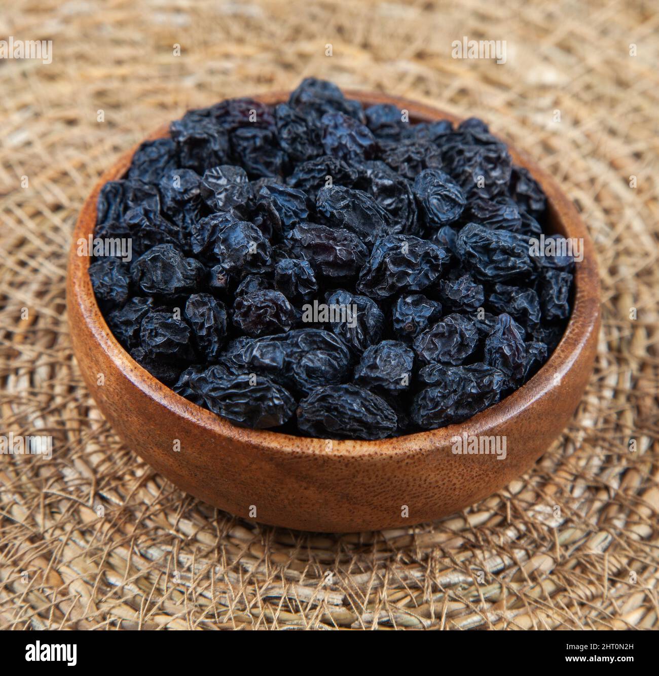 Black raisins full wooden bowl, top view Stock Photo - Alamy