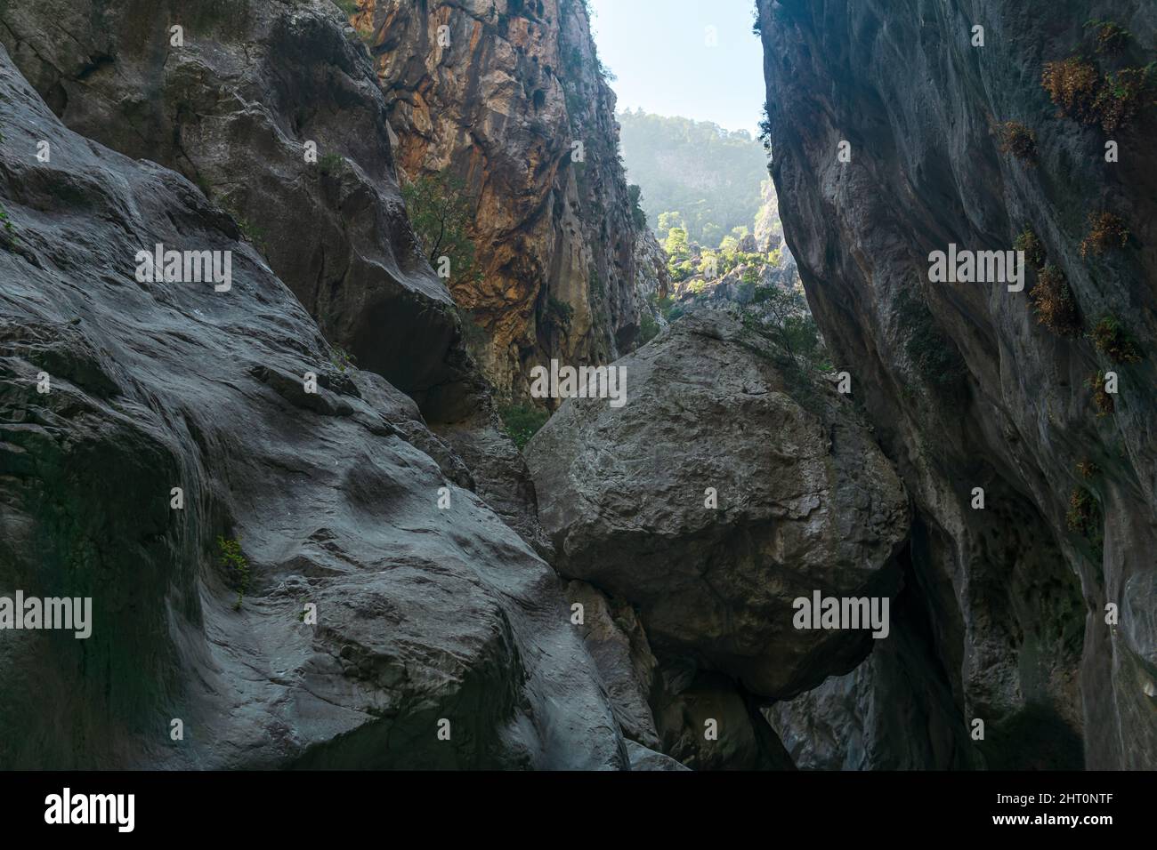 huge stone hangs stuck between two rocky walls of the Göynük canyon in ...