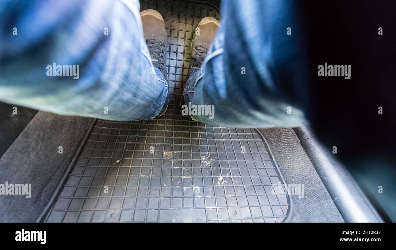 Low angle view of a person's feet on dirty the car carpet in the car ...