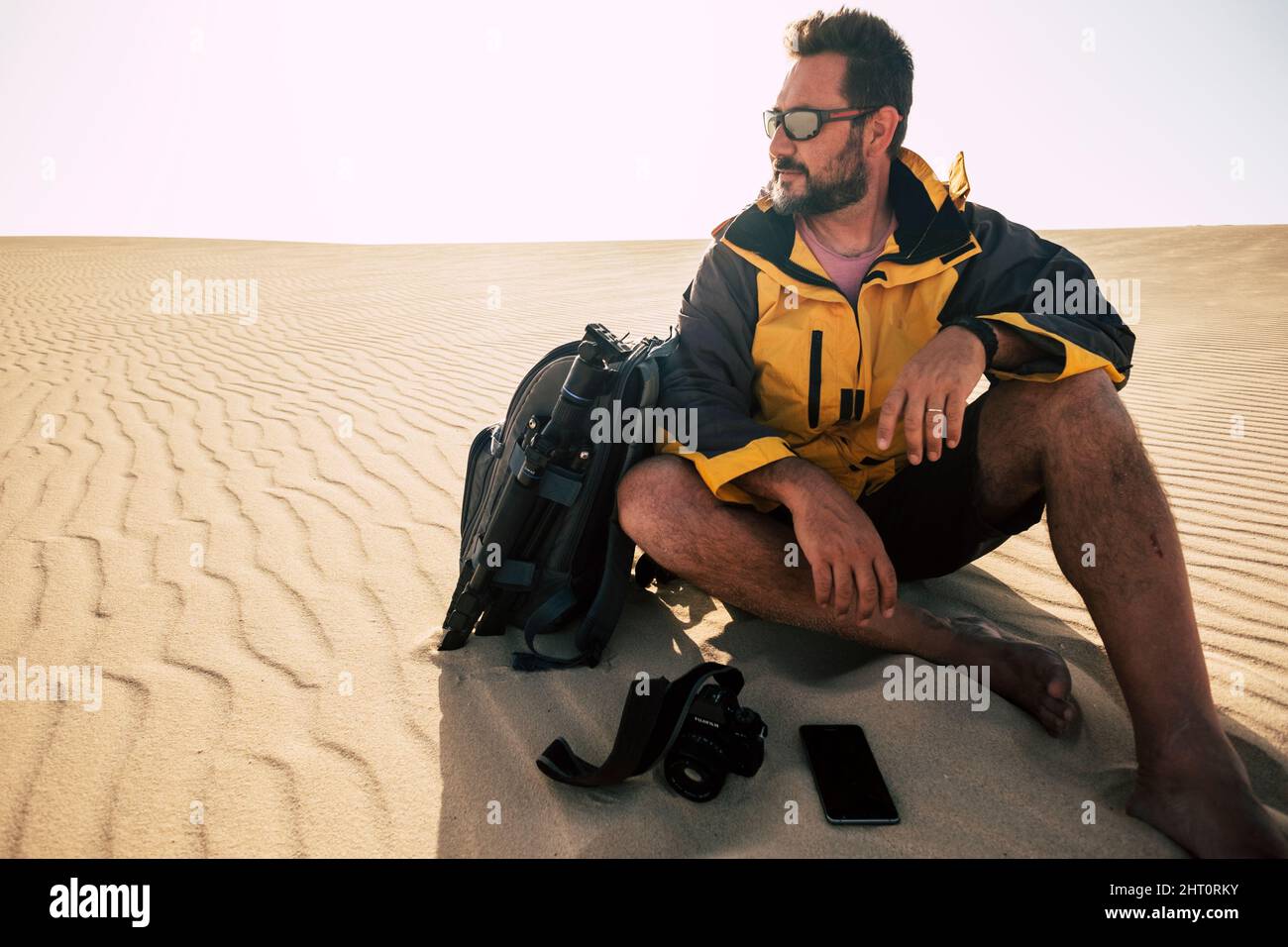 Young adult man explore desert sand dunes alone with backpack and photo ...