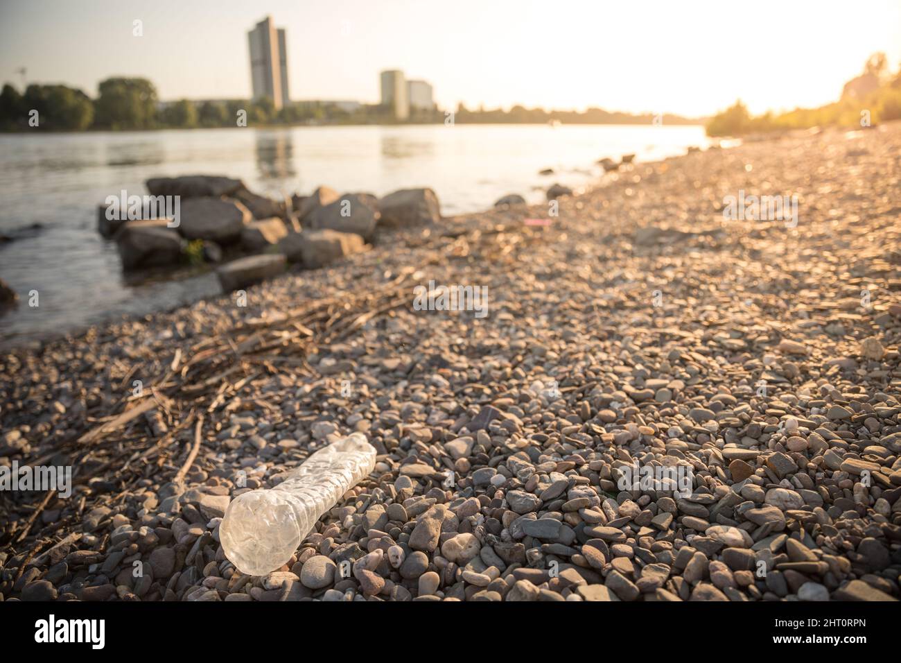 Closeup of a plastic bottle on the pebbles near the river - the concept ...