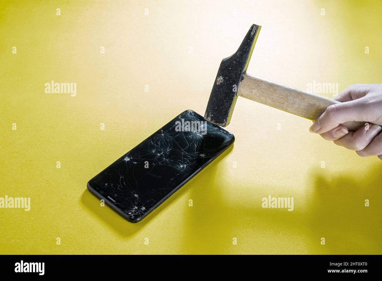 breaking the cellphone screen with a hammer Stock Photo - Alamy