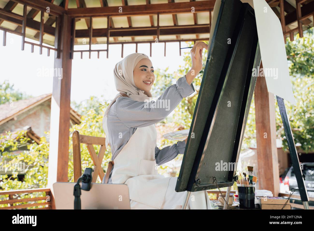 muslim Female artist painting on canvas at home studio Stock Photo - Alamy