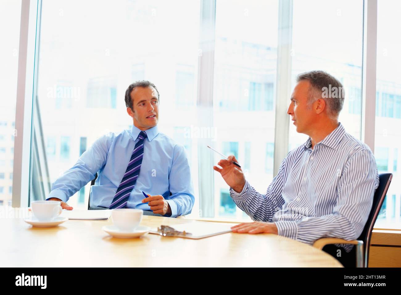 Executives discussing proposal. Colleagues indoors having conversation ...