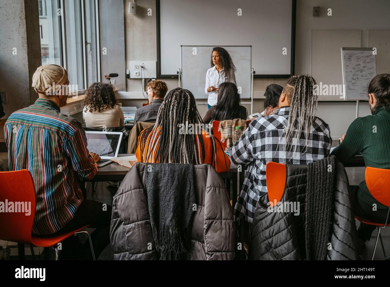Female professor teaching university students in classroom Stock Photo ...