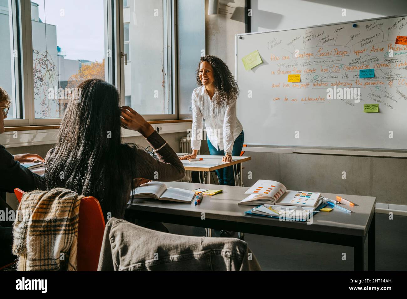 Teacher leaning on students desk hi-res stock photography and images ...