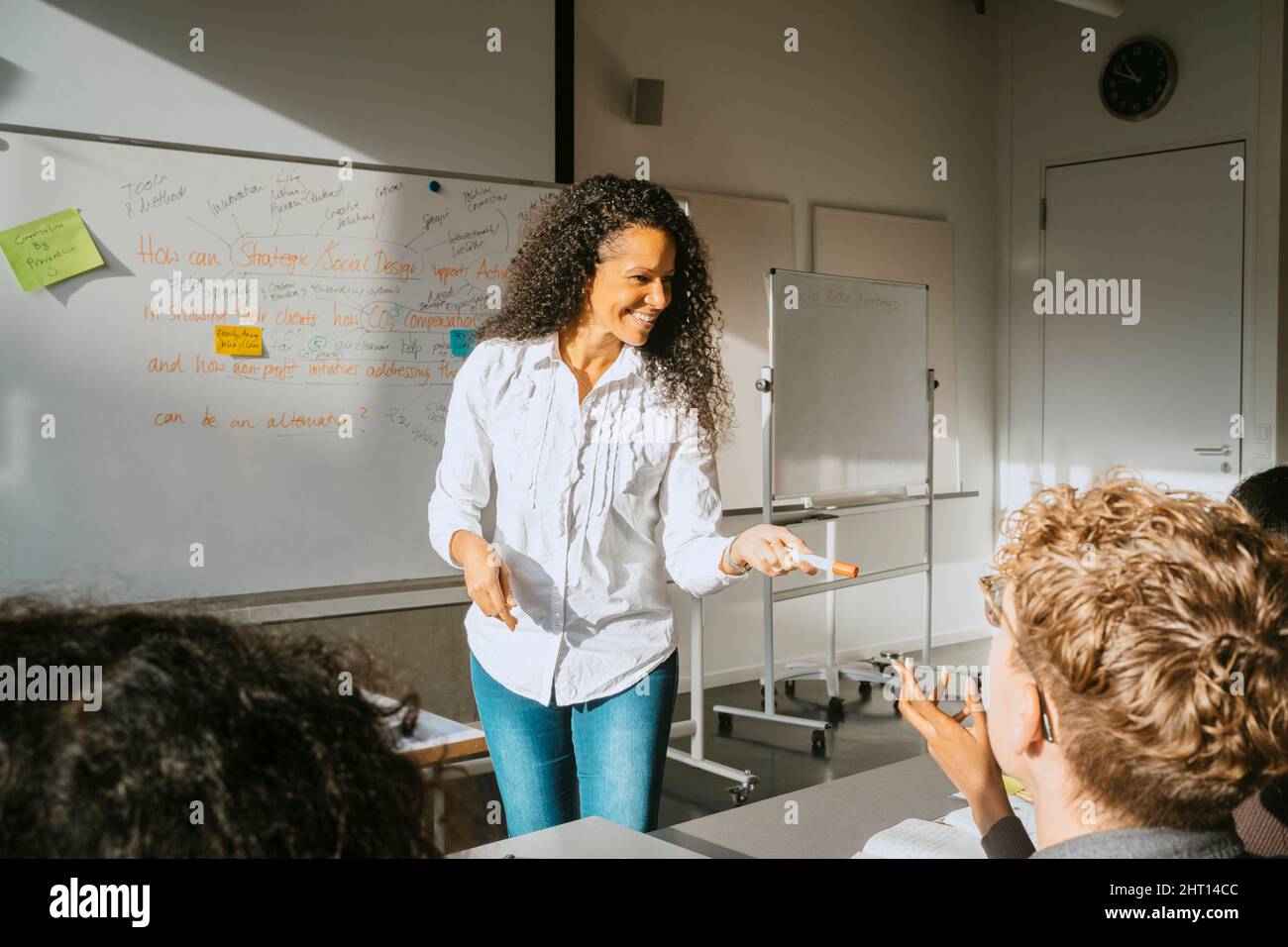 Smiling professor teaching university students in classroom Stock Photo ...