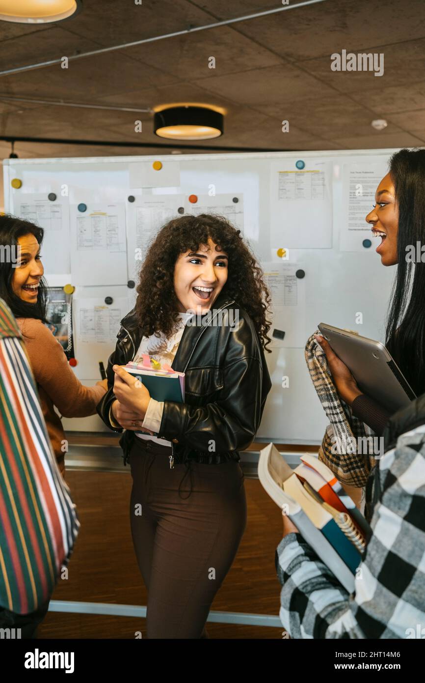 Happy woman shouting while looking at friends checking grades in ...