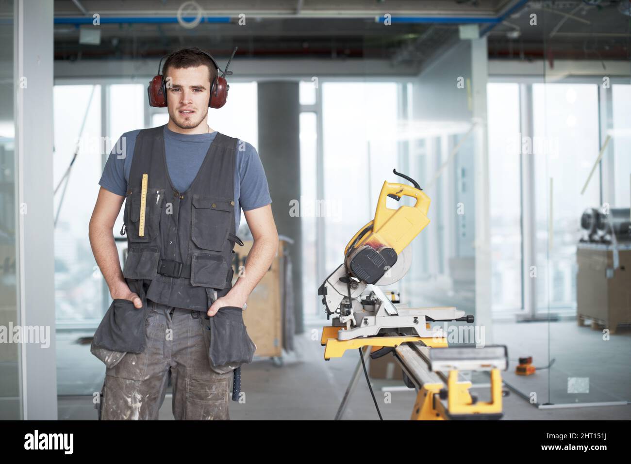 Hes well equipped to do the job. Handsome young contractor standing on ...