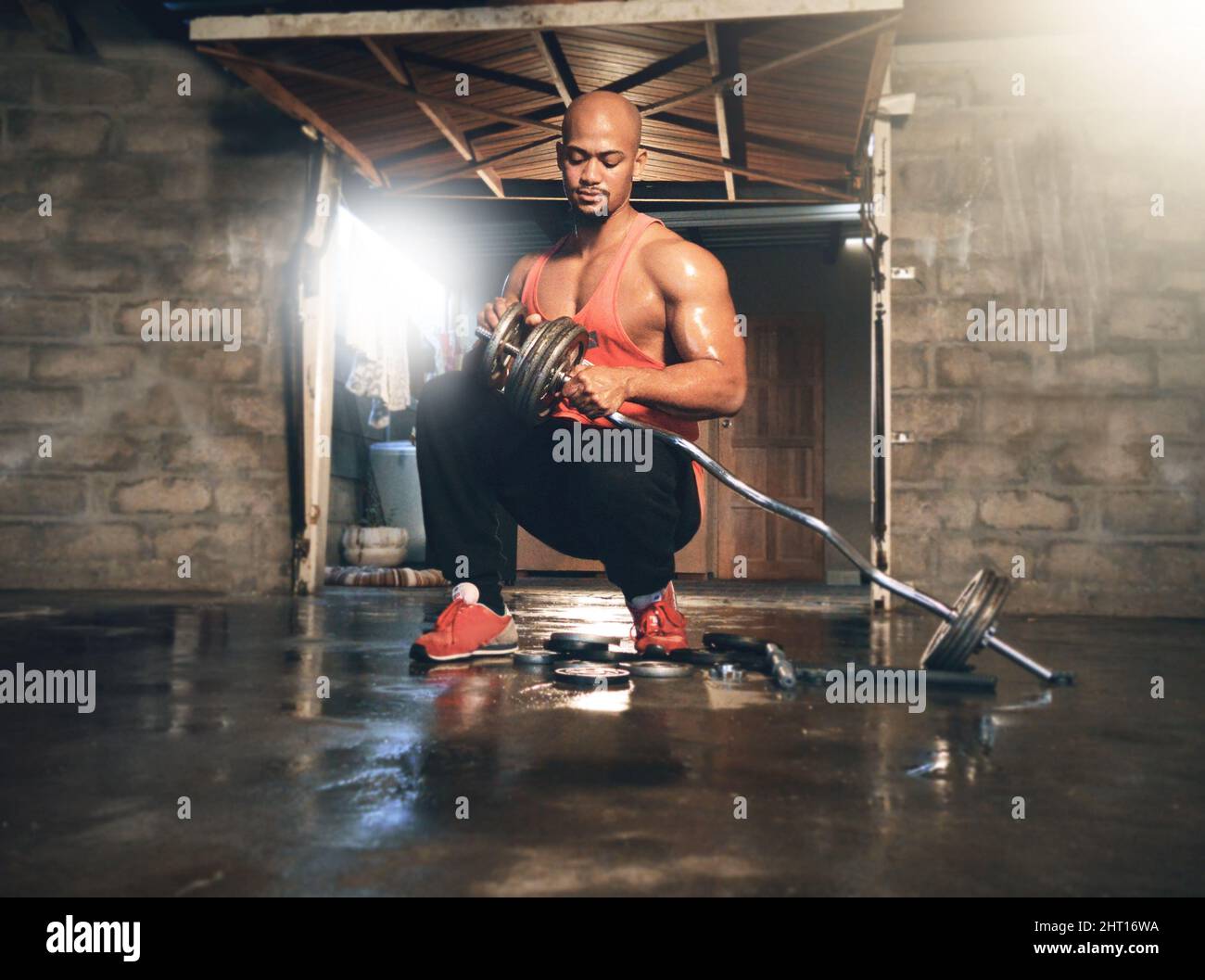 Adding more weight to his workout. Full length shot of a muscular young ...