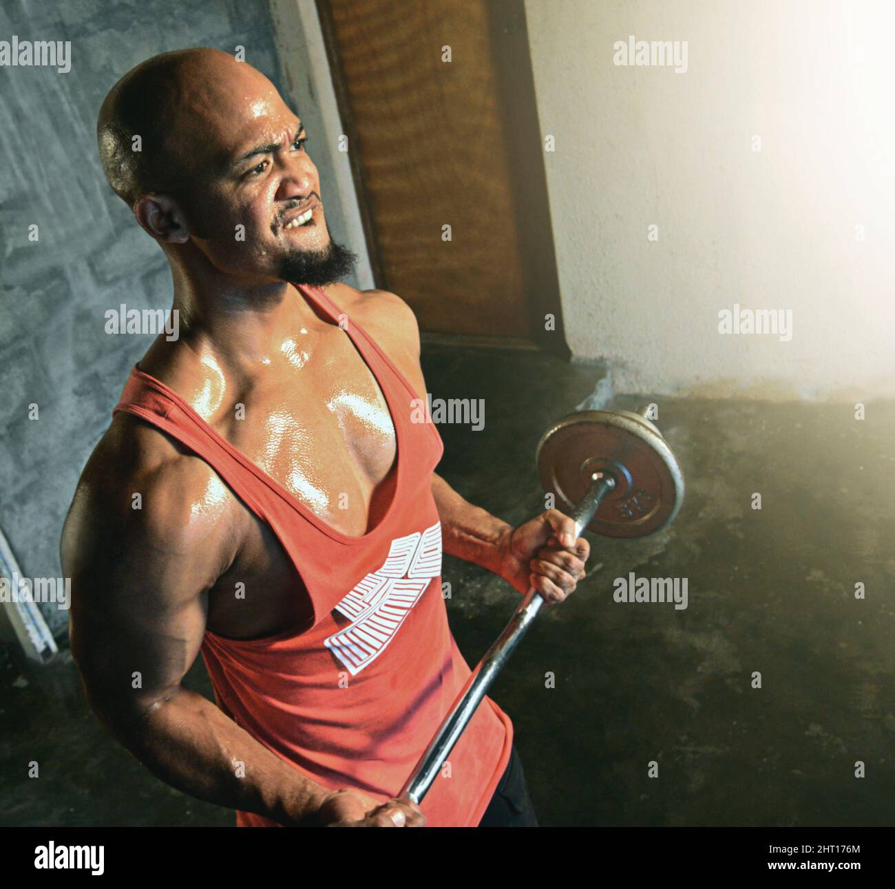 Building the perfect body. Cropped shot of a muscular young man lifting ...
