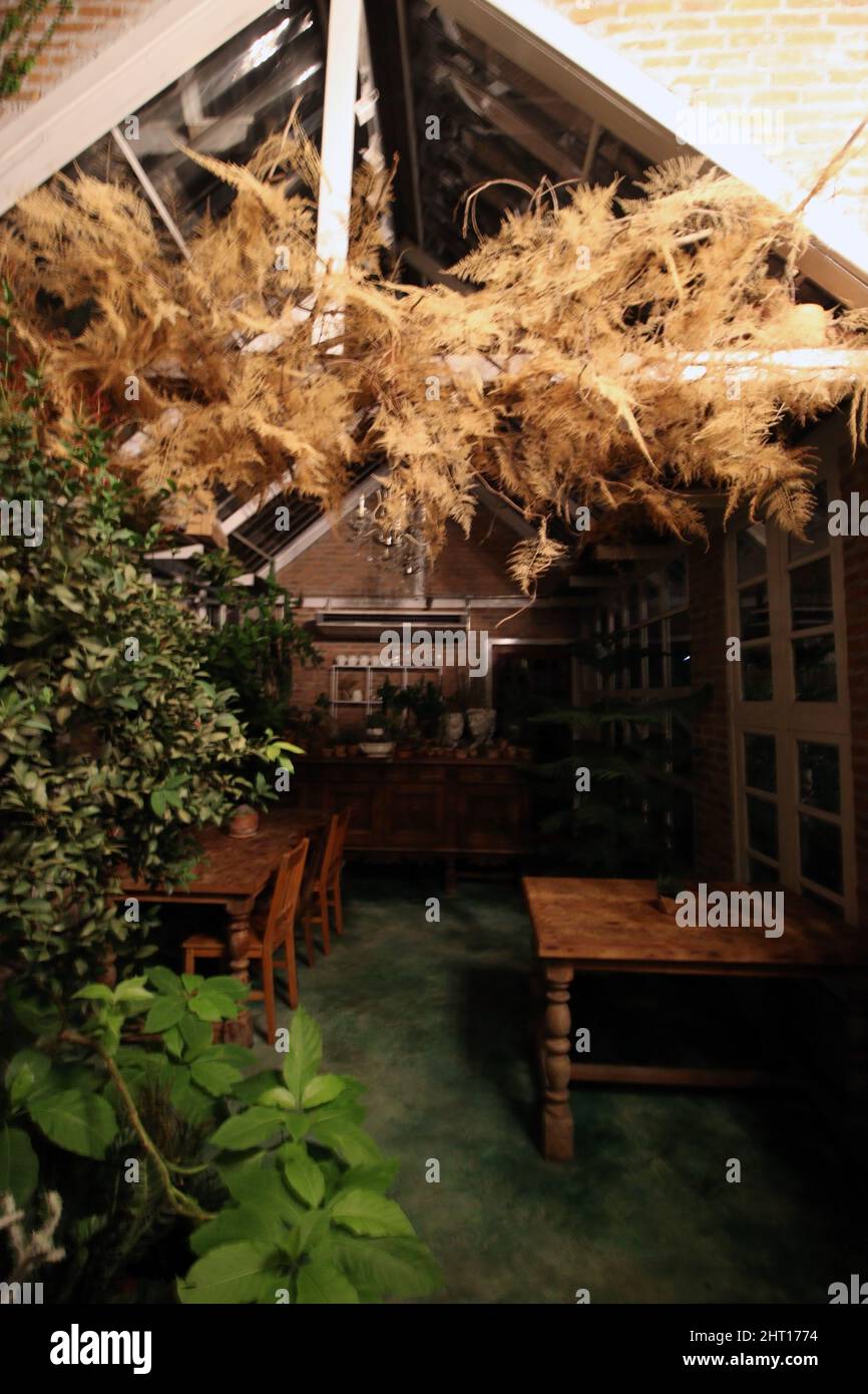 Vertical shot of a cafe interior with wooden tables and decorative ...