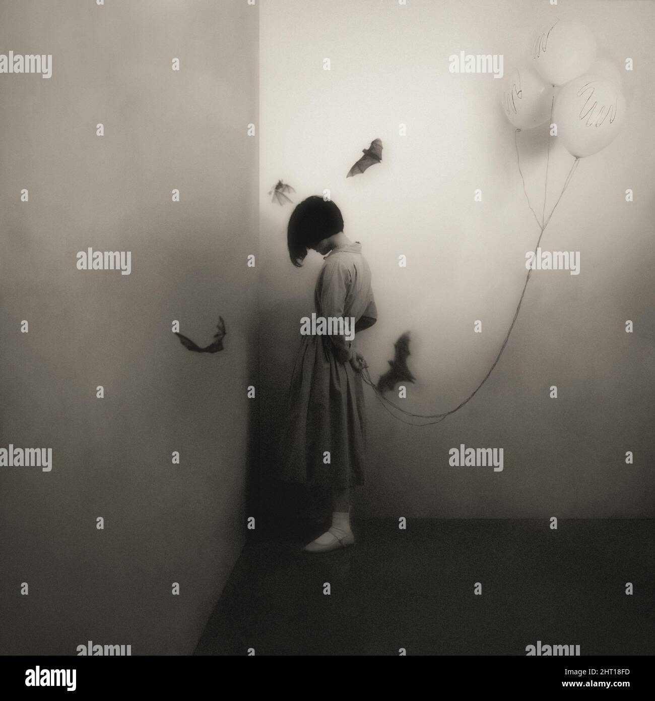 Grayscale shot of a sad lonely child girl in the corber on an empty ...